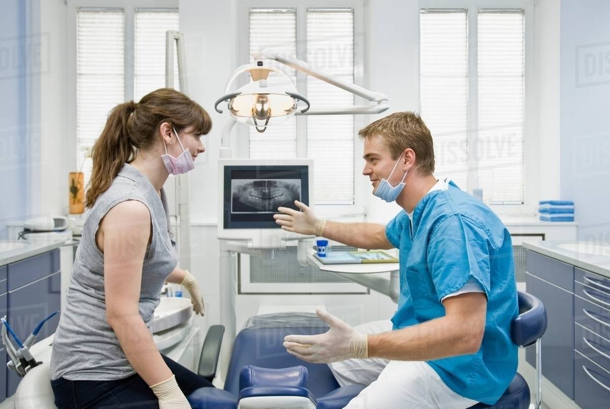 Dentist talking with assistant - Royalty-free Stock Photo | Dissolve