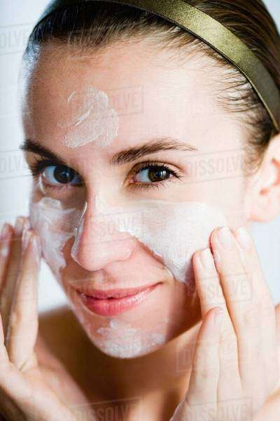 Woman putting face mask on - Stock Photo - Dissolve
