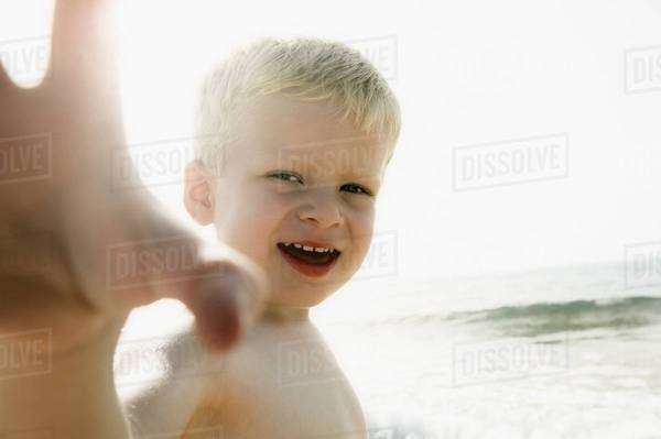 Boy reaching out to camera - Stock Photo - Dissolve