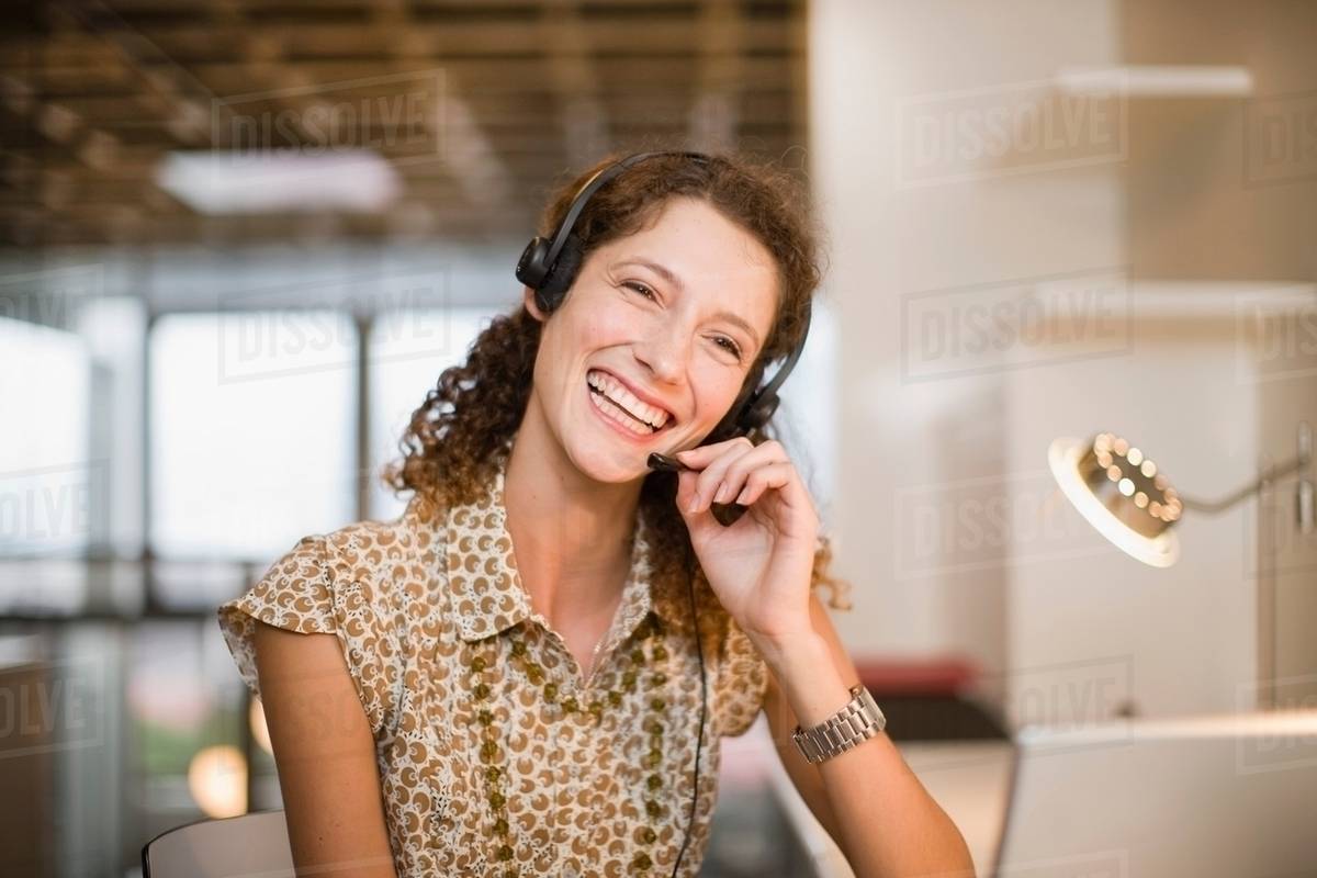 Smiling woman wearing headset - Royalty-free Stock Photo | Dissolve
