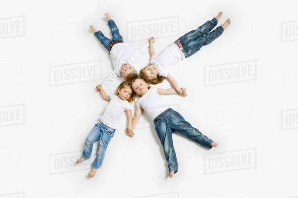 Four toddlers laying in formation - Stock Photo - Dissolve