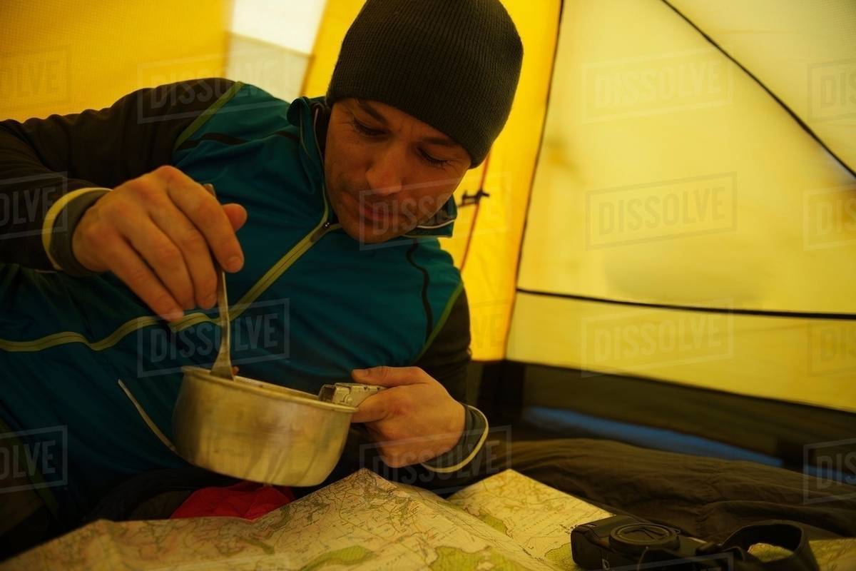 Man eating in camping tent - Royalty-free Stock Photo | Dissolve