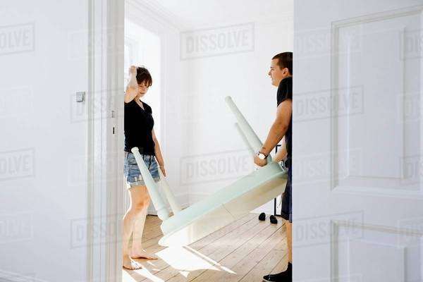 Couple carrying table in new home - Royalty-free Stock Photo | Dissolve