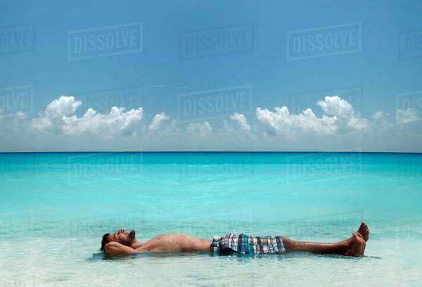 Man floating in water at tropical beach - Royalty-free Stock Photo ...