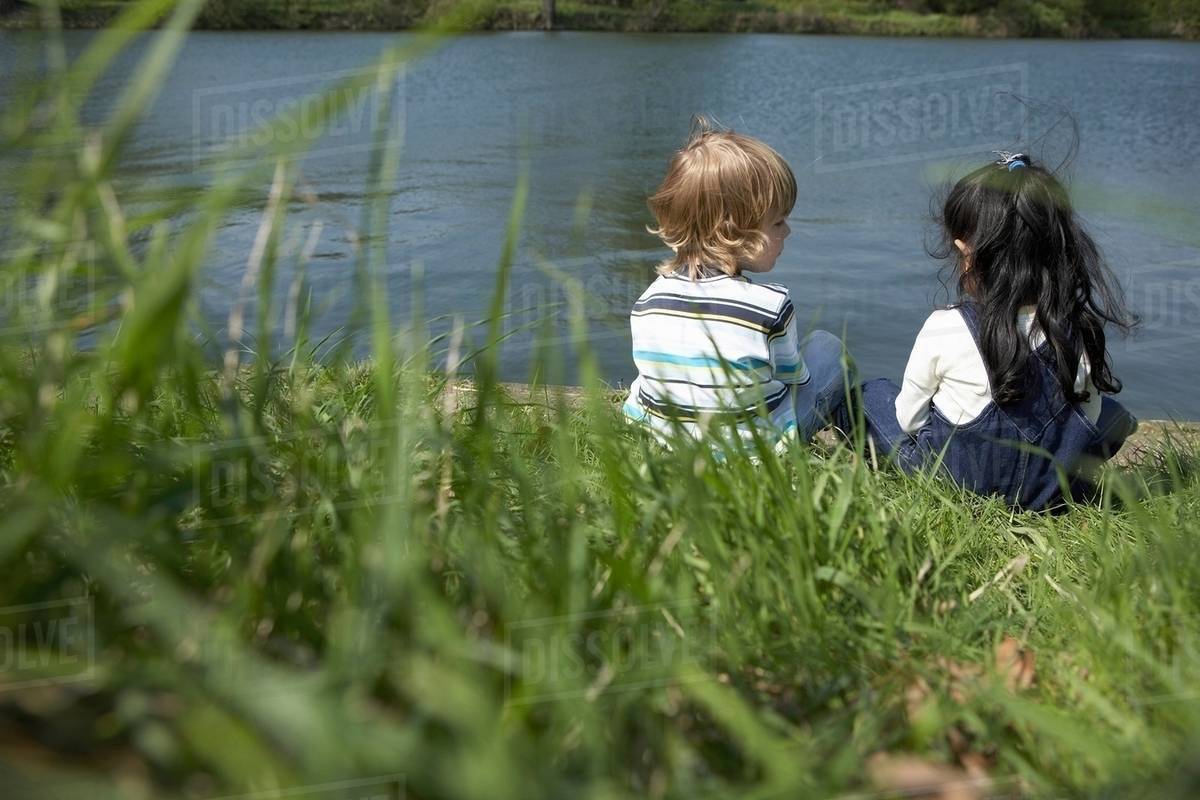 Children sitting on riverbank together - Royalty-free Stock Photo ...