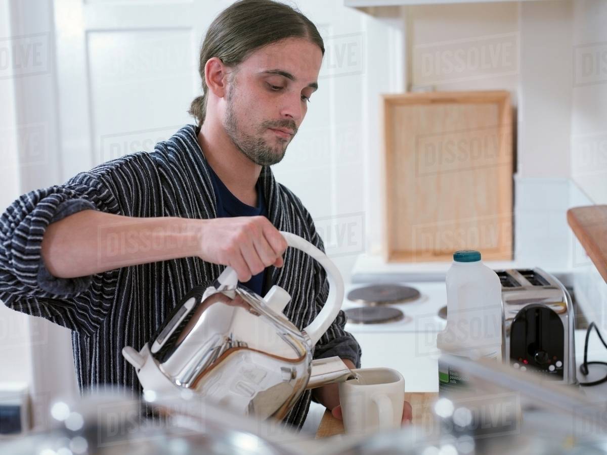 Man making cup of tea in kitchen - Stock Photo - Dissolve