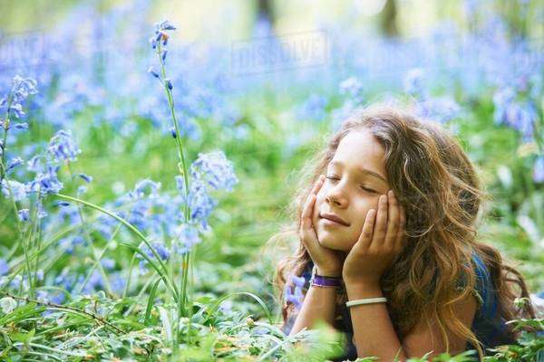 Girl laying in field of flowers - Stock Photo - Dissolve