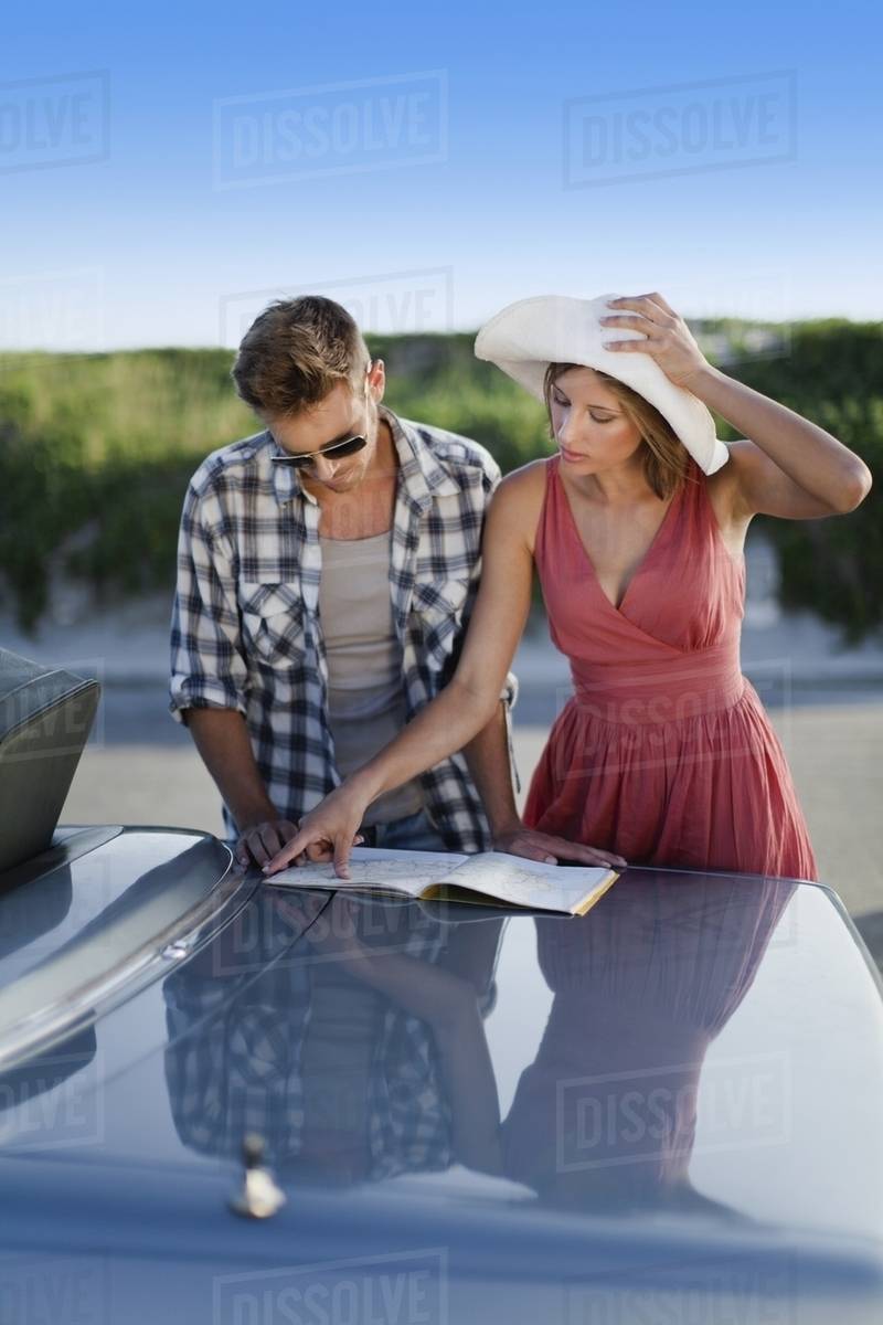 Couple reading map on roadside - Royalty-free Stock Photo | Dissolve