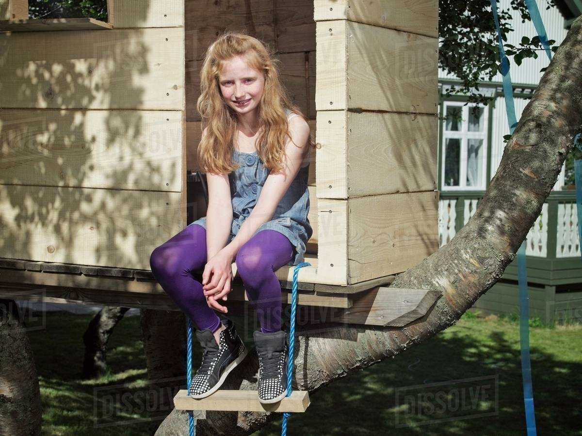 Girl playing in treehouse - Stock Photo - Dissolve