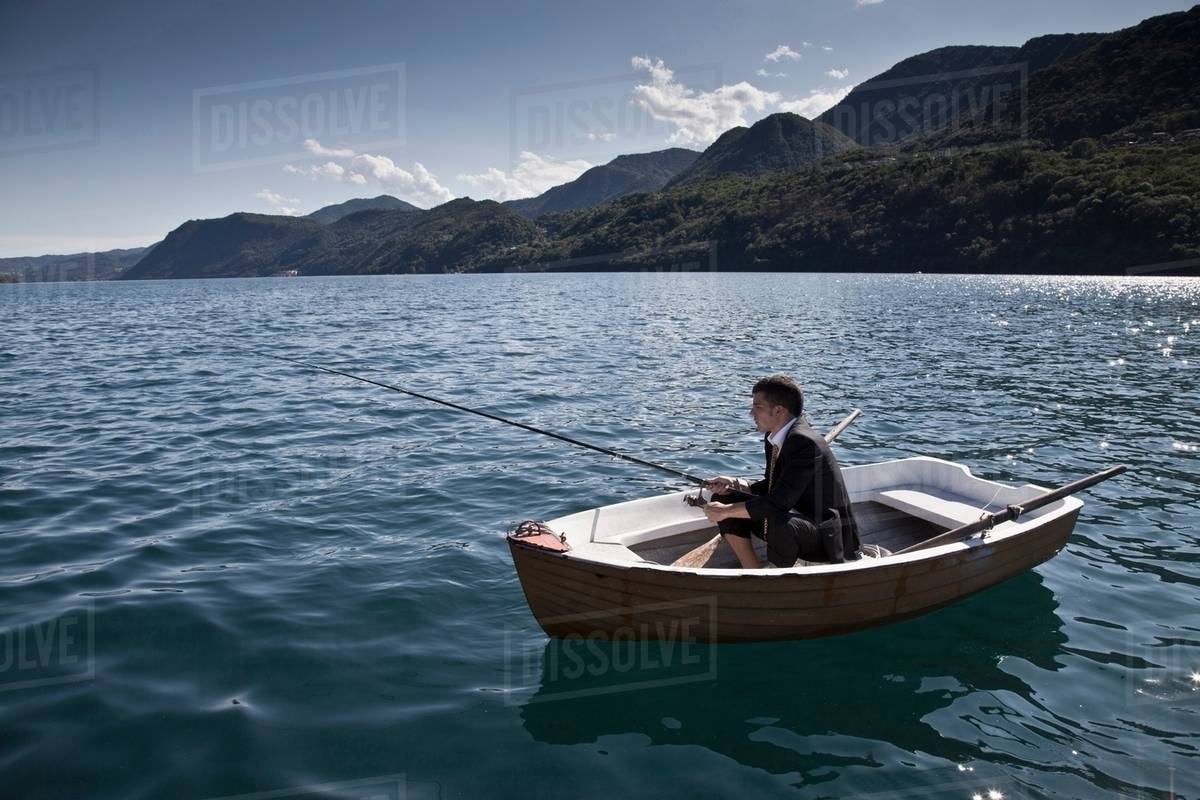 Businessman fishing in rowboat - Royalty-free Stock Photo | Dissolve