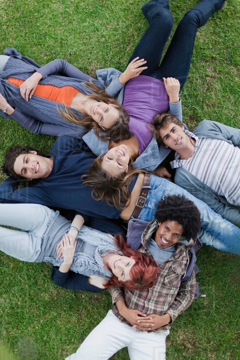 Students laying in grass on campus - Royalty-free Stock Photo | Dissolve