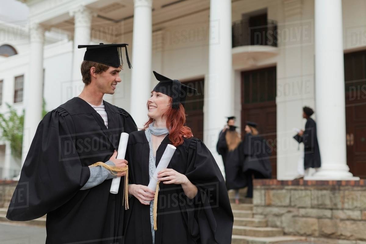 Graduates with their degrees on campus - Stock Photo - Dissolve