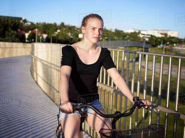 Woman riding bicycle on skybridge - Royalty-free Stock Photo | Dissolve