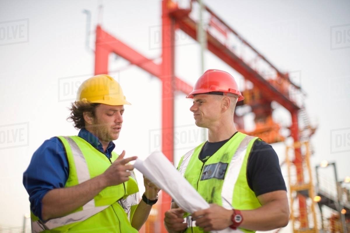 Construction workers talking on site - Royalty-free Stock Photo | Dissolve