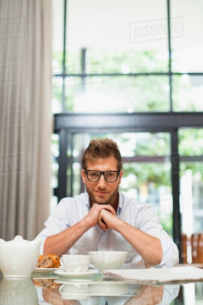 Smiling man sitting at breakfast - Stock Photo - Dissolve