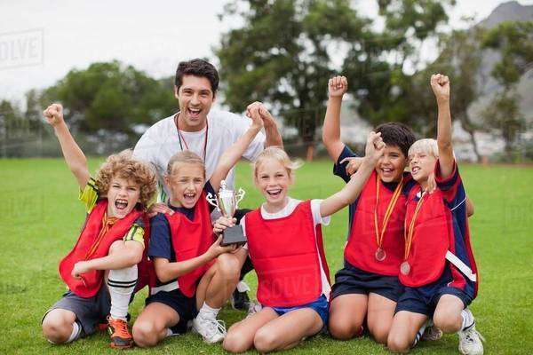 Children cheering with coach - Royalty-free Stock Photo | Dissolve