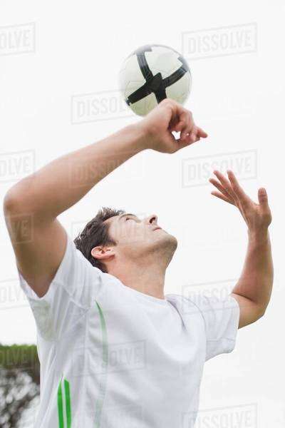 Man playing with soccer ball in field - Stock Photo - Dissolve