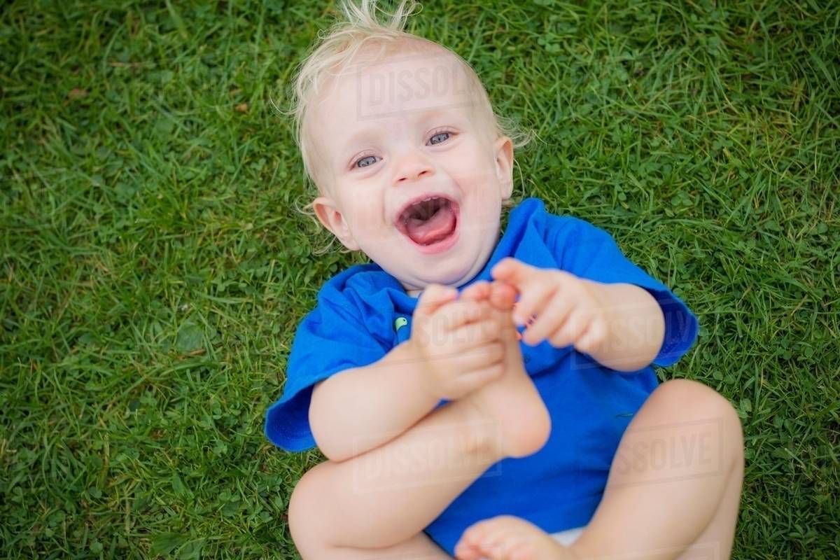 Baby boy playing with his feet - Royalty-free Stock Photo | Dissolve