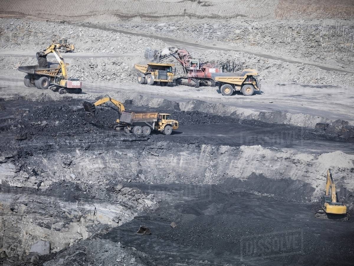 Digger loading coal into dumper truck in opencast coalmine - Stock ...