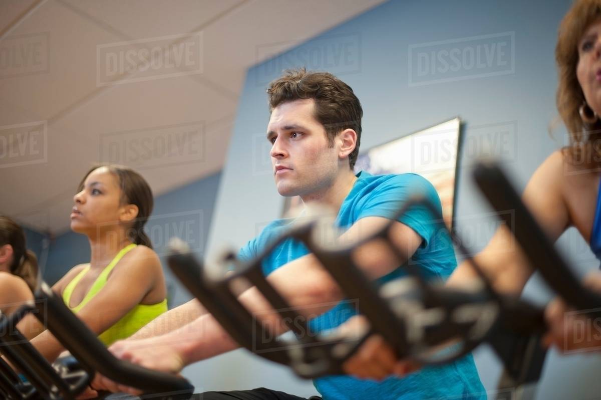 People using spin machines in gym - Stock Photo - Dissolve