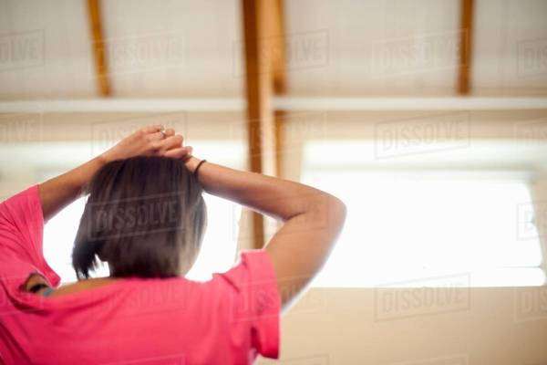 Woman resting hands on her head - Stock Photo - Dissolve
