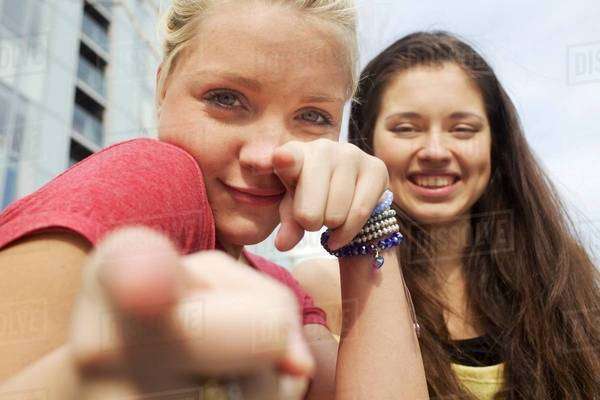 Girls making faces on city street - Royalty-free Stock Photo | Dissolve
