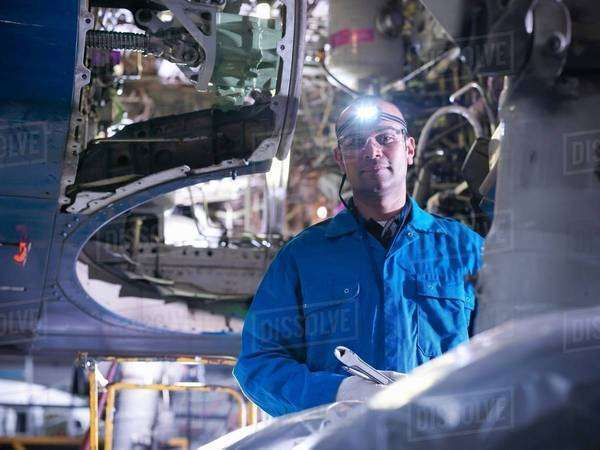 Aircraft engineer working on undercarriage area of 737 jet plane ...