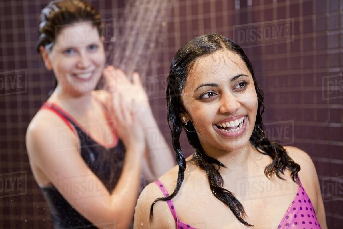 Smiling women showering in pool - Stock Photo - Dissolve