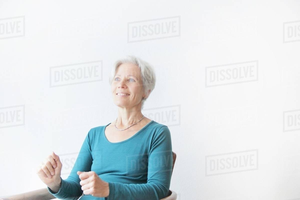 Smiling older woman sitting in chair - Royalty-free Stock Photo | Dissolve