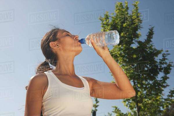 Woman drinking water outdoors - Royalty-free Stock Photo | Dissolve