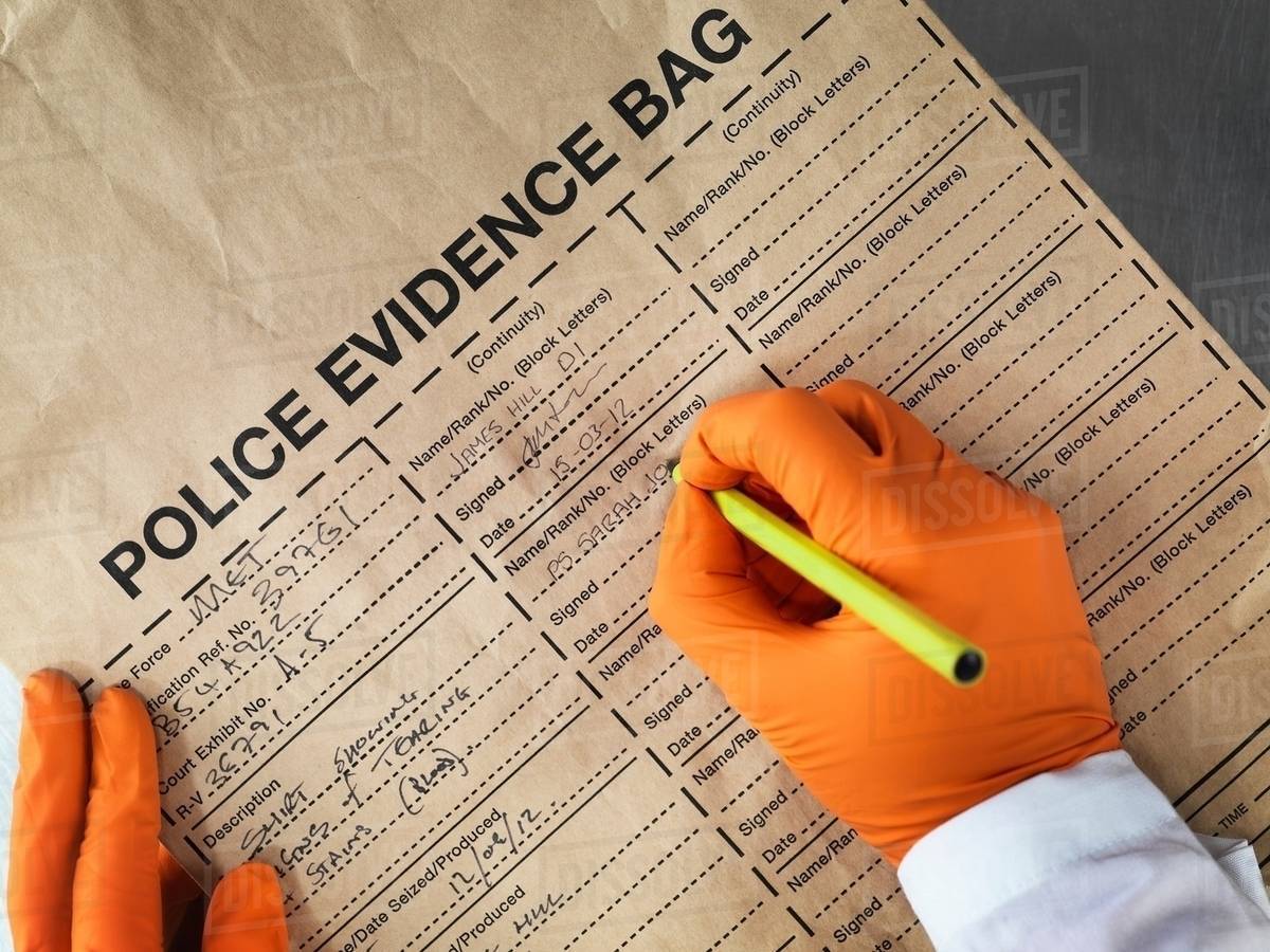 Scientist filling out evidence bag - Royalty-free Stock Photo | Dissolve