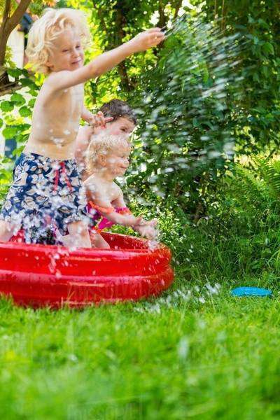 Children splashing in paddling pool - Royalty-free Stock Photo | Dissolve