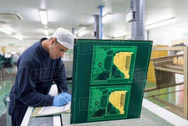 Worker creating circuit board printing machine in circuit board factory ...