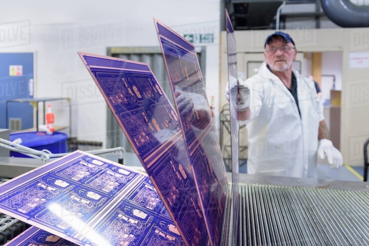 Worker operating circuit board processing machine in circuit board ...