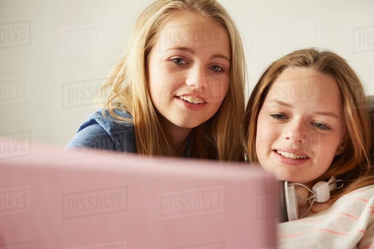 Two girls on sofa using digital tablet - Stock Photo - Dissolve