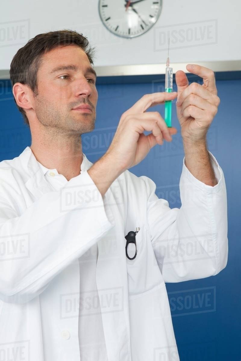 Doctor inspecting injection - Royalty-free Stock Photo | Dissolve