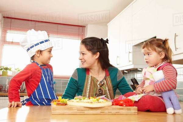 Mother cooking with children in kitchen - Royalty-free Stock Photo ...