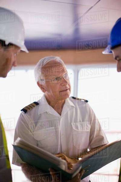 Captain of a ship talking to workers - Stock Photo - Dissolve