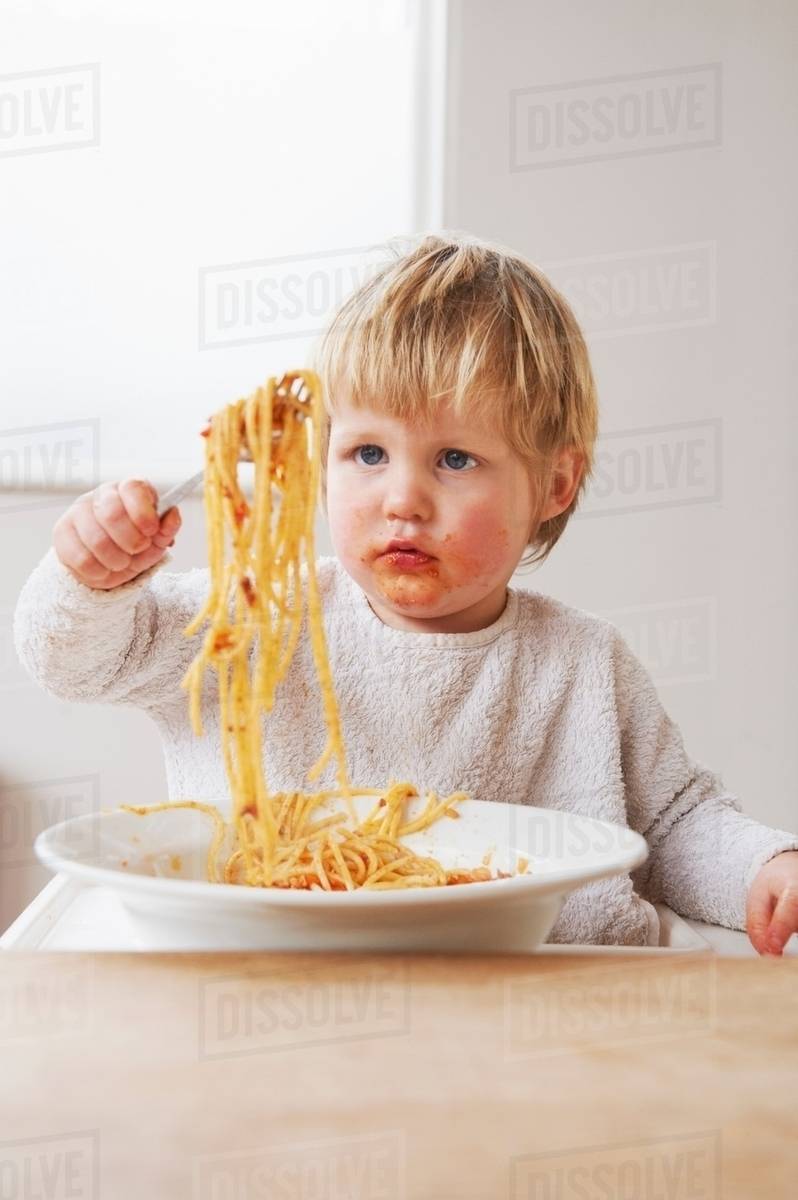 Messy baby boy eating spaghetti - Royalty-free Stock Photo | Dissolve