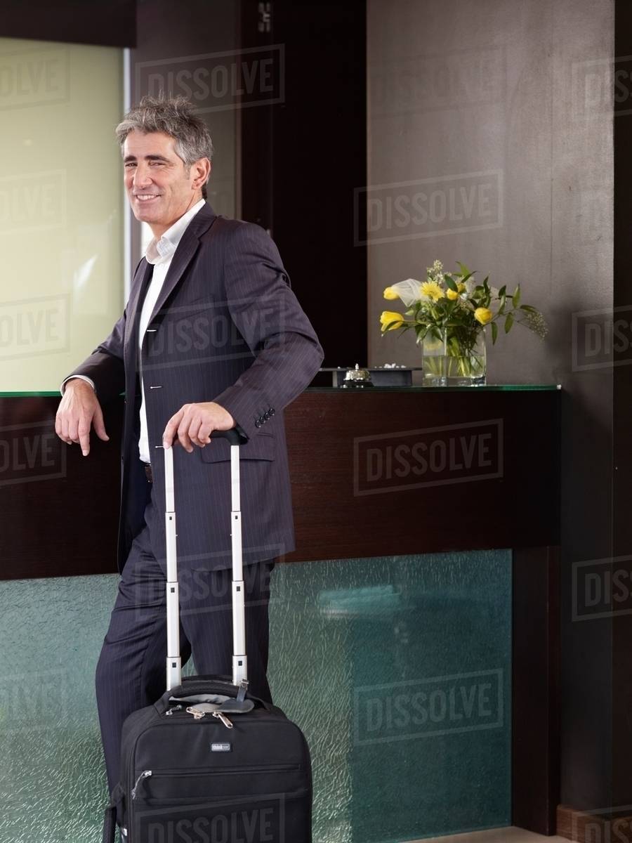 Portrait of senior business man at the front desk of a hotel - Royalty ...