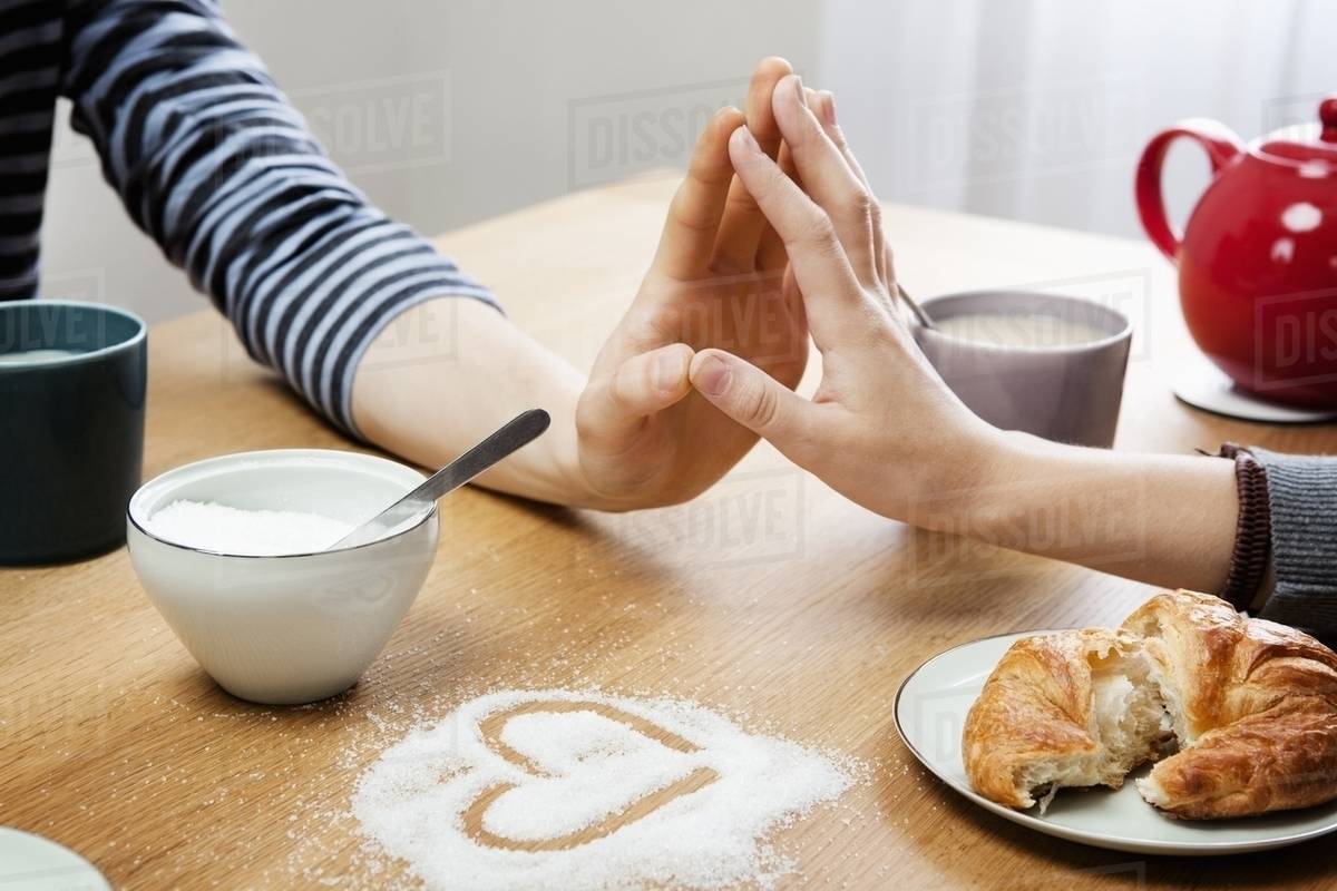 Two hands touching over table - Stock Photo - Dissolve