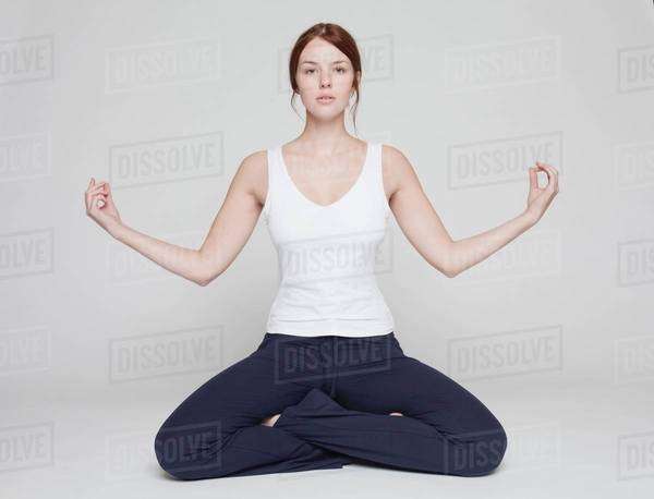 Girl in lotus position on white background - Stock Photo - Dissolve