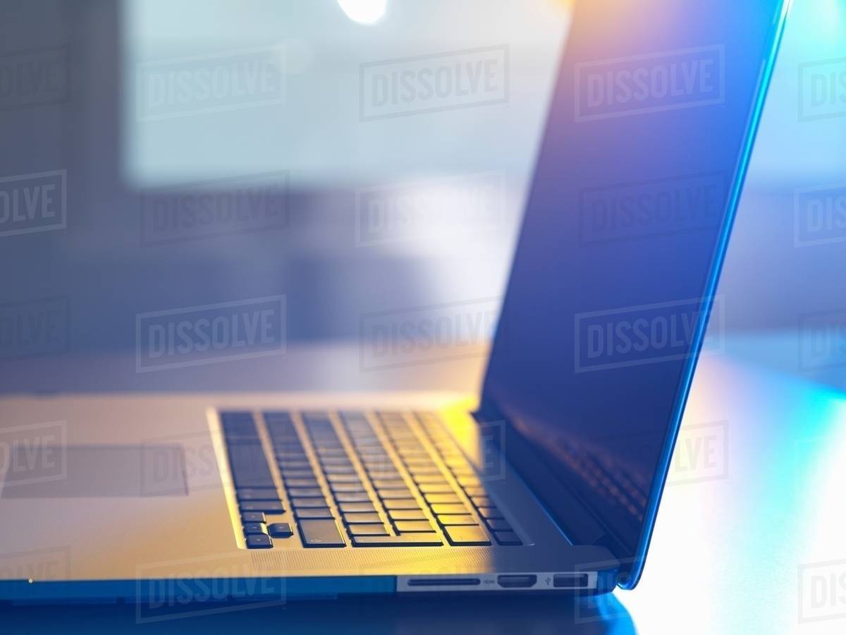 Side view of open laptop on desk - Royalty-free Stock Photo | Dissolve