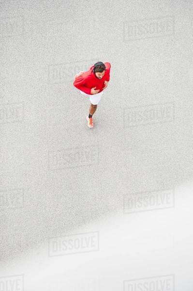 Overhead view of young male runner running in empty urban space - Stock ...
