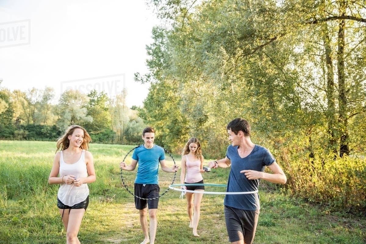Group of friends in field, using hula hoops - Royalty-free Stock Photo ...