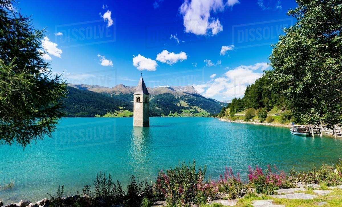Church spire in turquoise lake, Trentino Alto Adige, Italy - Royalty ...