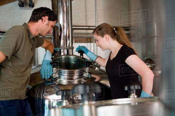 Female brewer working in brewhouse - Royalty-free Stock Photo | Dissolve