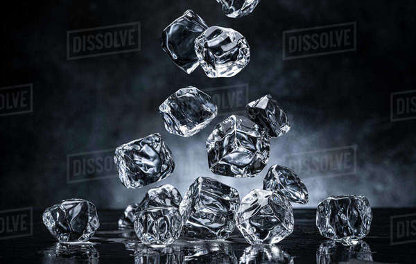 Falling ice cubes and translucent crushed ice heap on black background ...