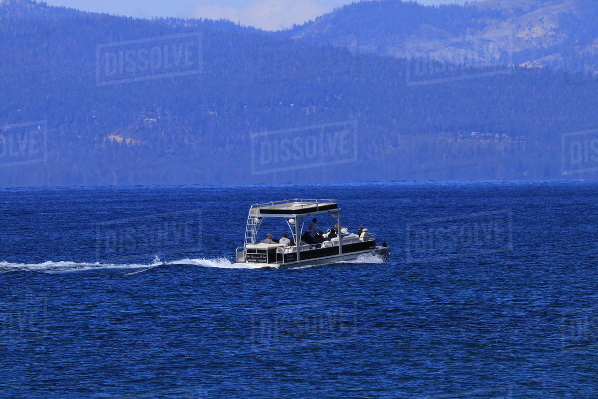 A Pontoon Boat on Lake Tahoe California with blue water and Mountains ...