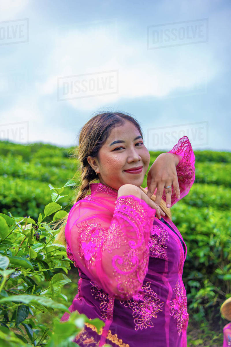 an Asian woman in a traditional pink costume is standing very elegantly ...